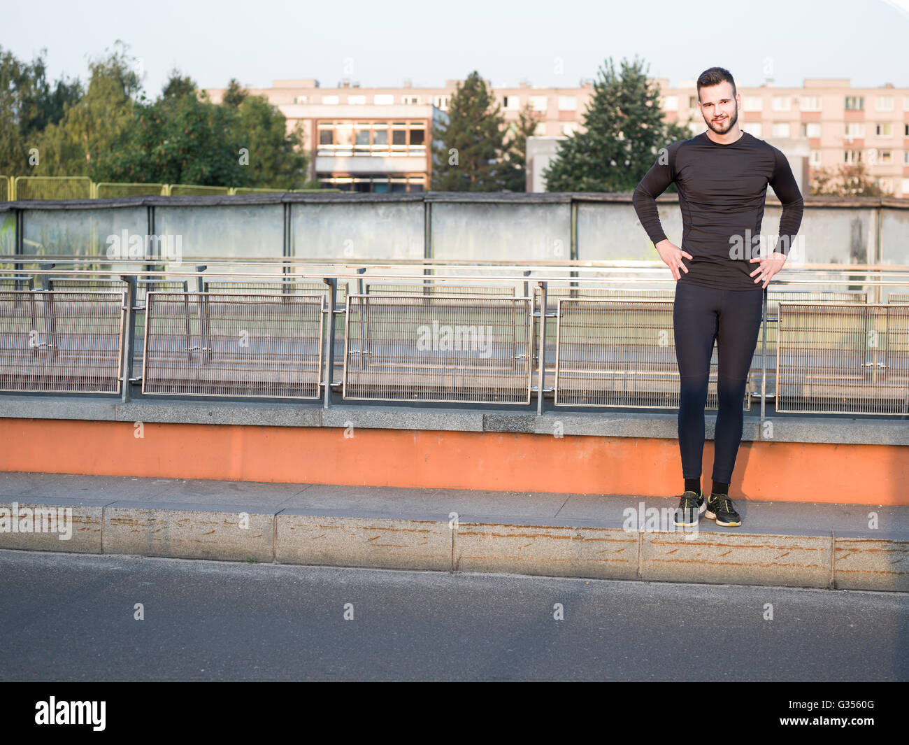 Young male runner taking a break on urban bridge Stock Photo - Alamy