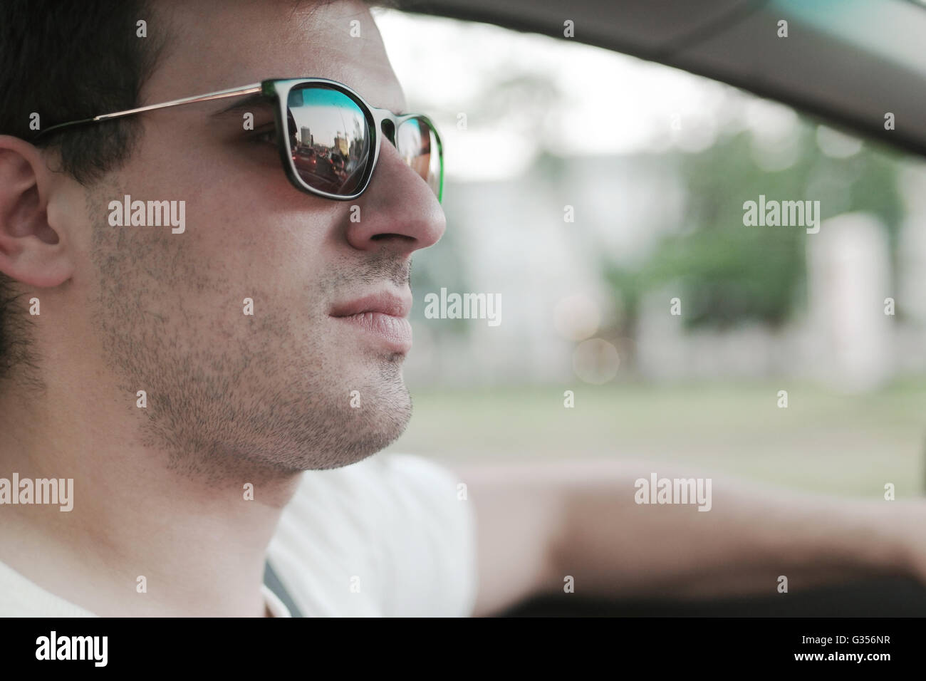 side view of a young man driving his convertible car Stock Photo - Alamy