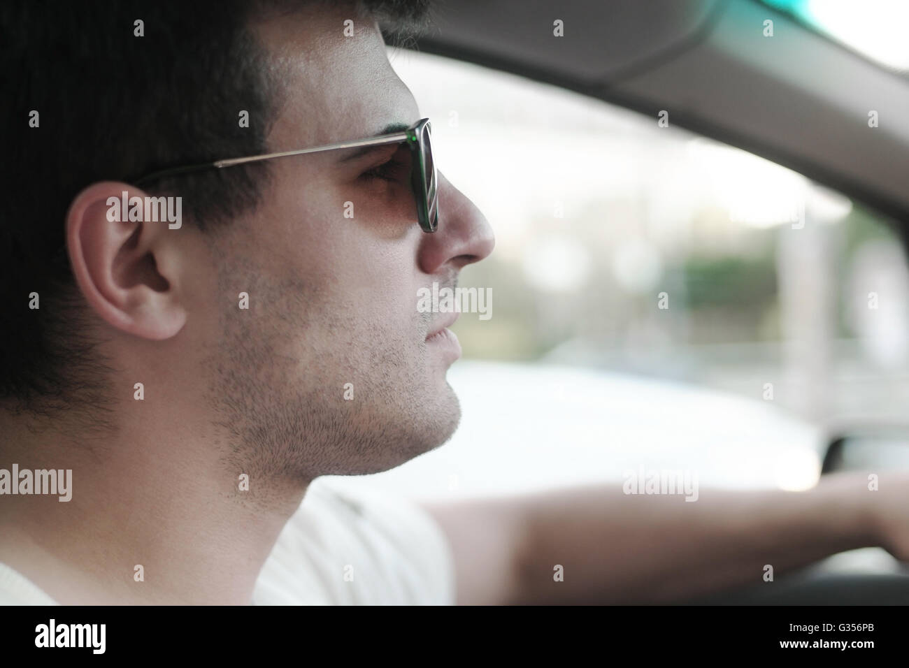 side view of a young man driving his convertible car Stock Photo - Alamy