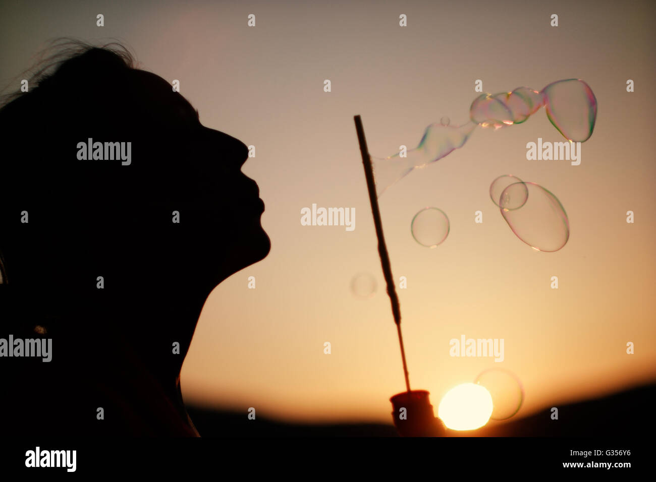 Happy blowing bubbles in the park at sunset. instagram tone, retro tone ...