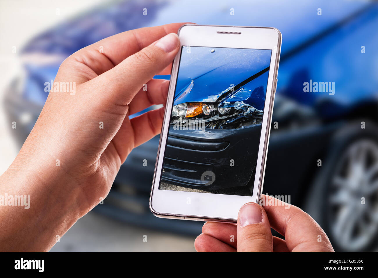 a woman using a smart phone to take a photo of the damage to her car ...