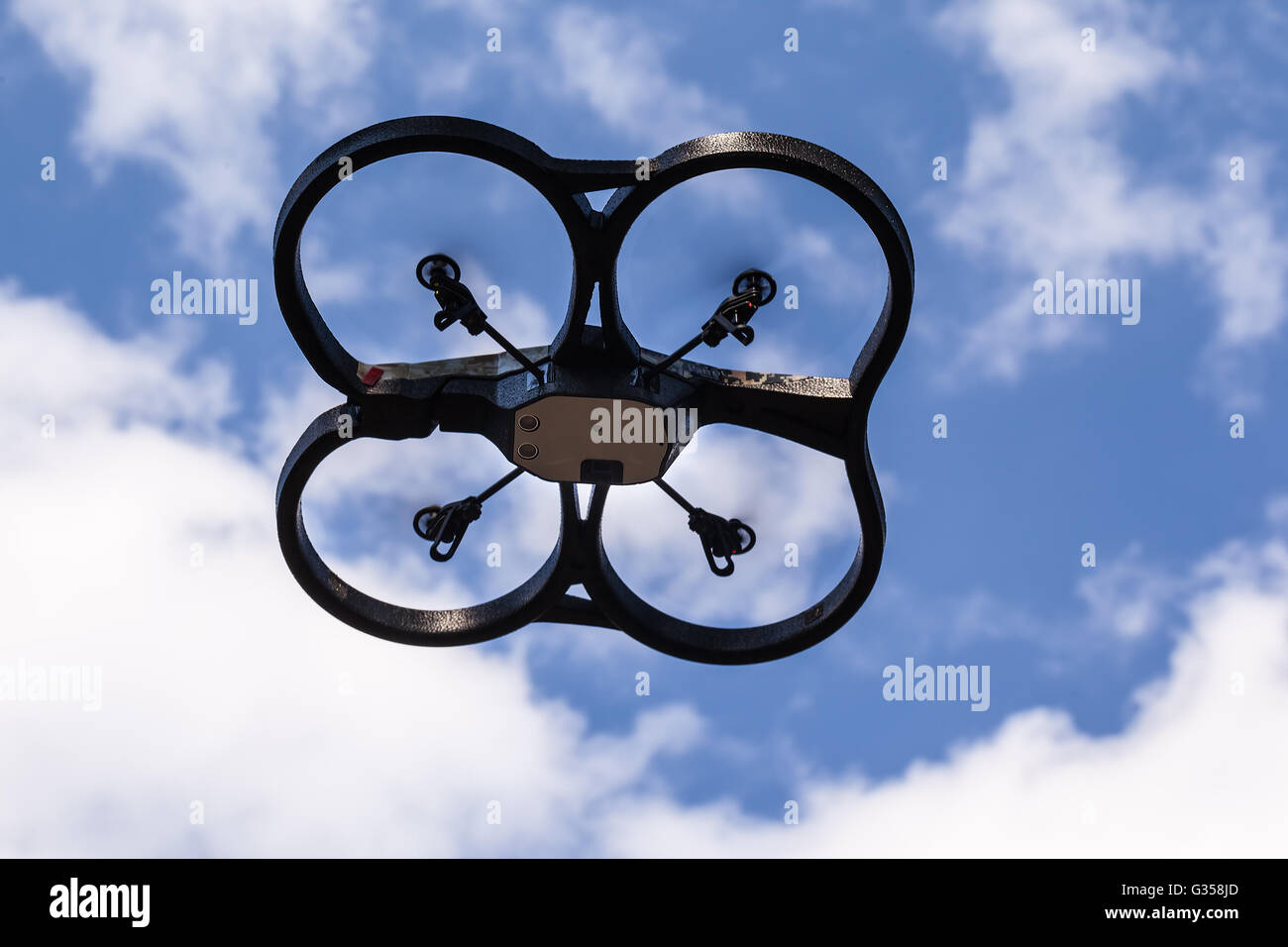 a small spy quad copter drone flying over a dramatic blue sky with ...