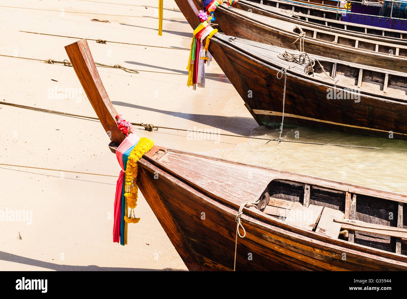 The bow of a traditional thai long tail boat decorated with ribbons and ...