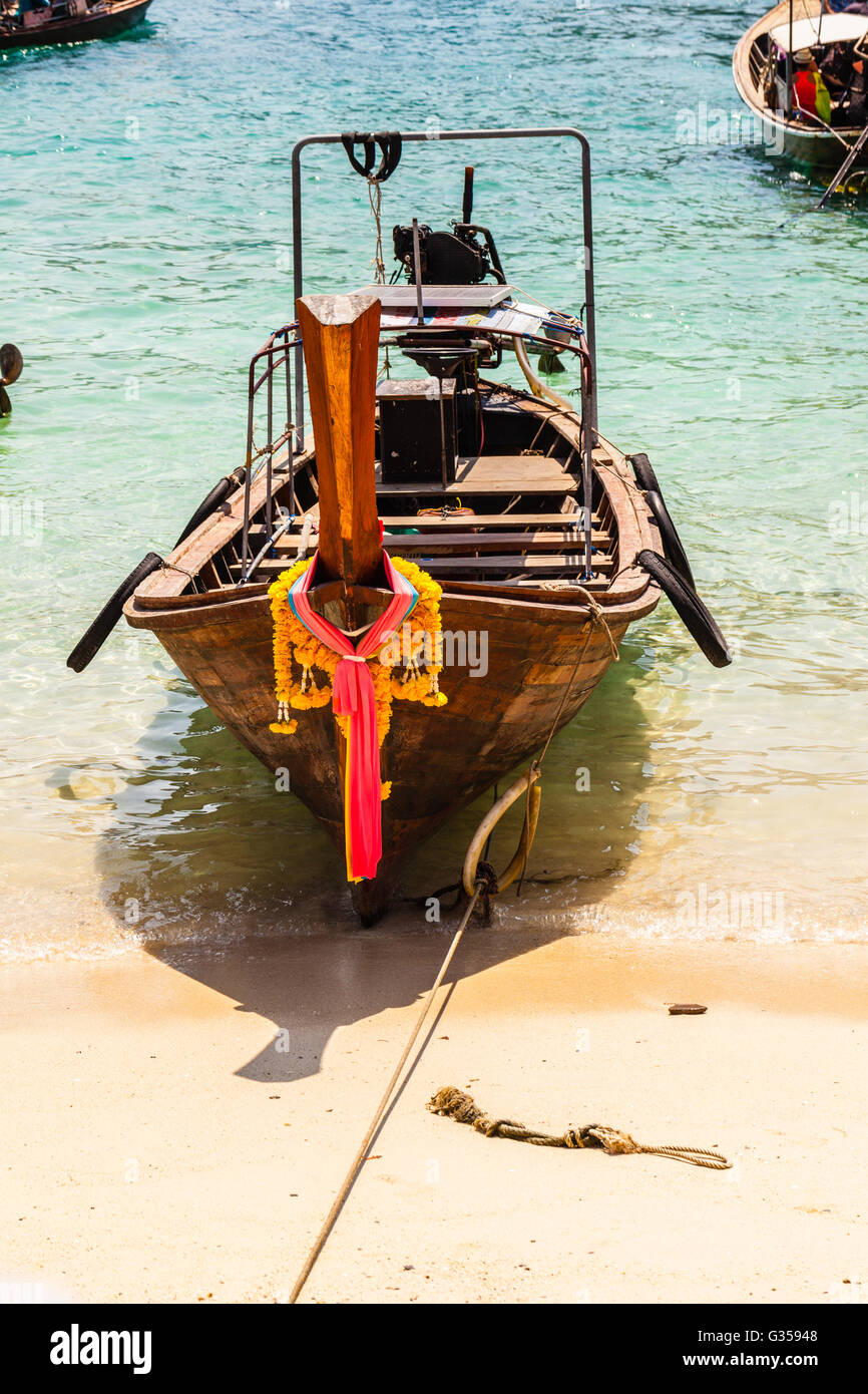 The bow of a traditional thai long tail boat decorated with ribbons and ...