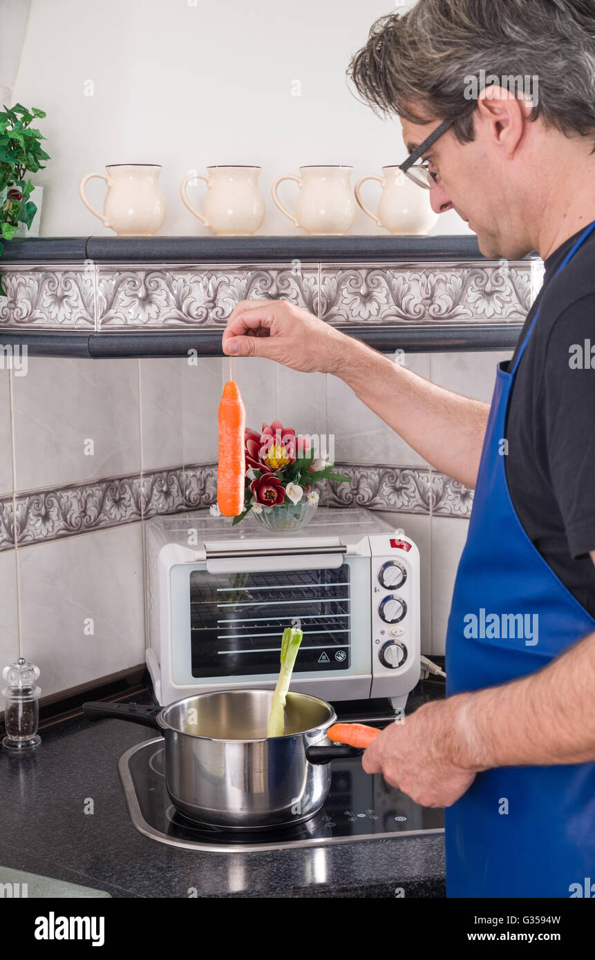 Guy throwing all sorts of vegetables in a pot Stock Photo - Alamy
