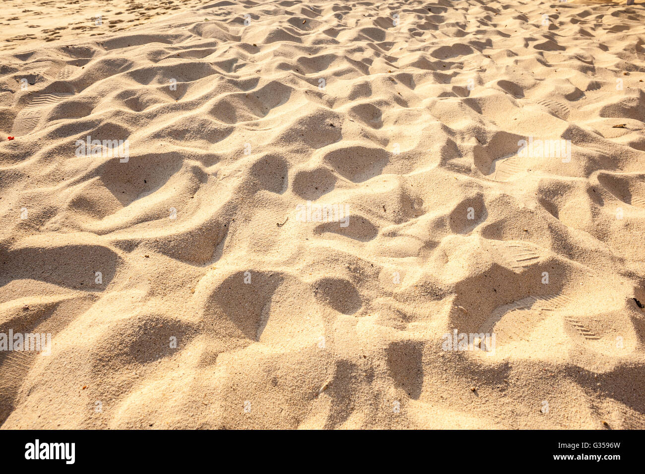 close up shot of the clean sand on a tropical island with footprints ...