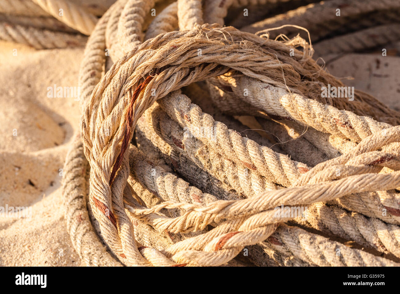 an old coiled rope on the sand of a tropical beach Stock Photo - Alamy