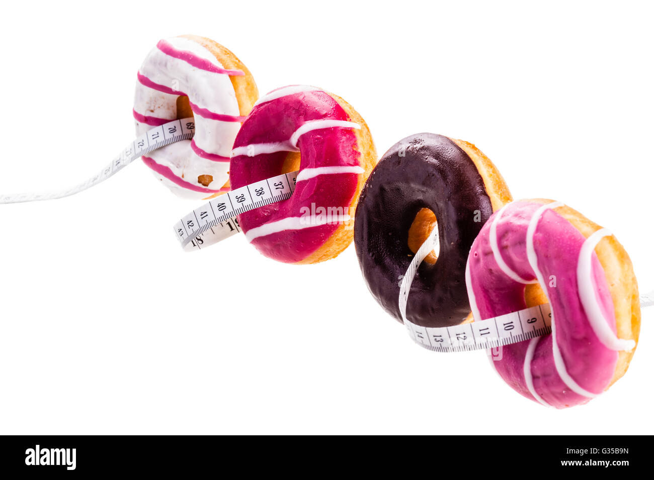 some delicious and colorful donuts with measuring tape Stock Photo - Alamy