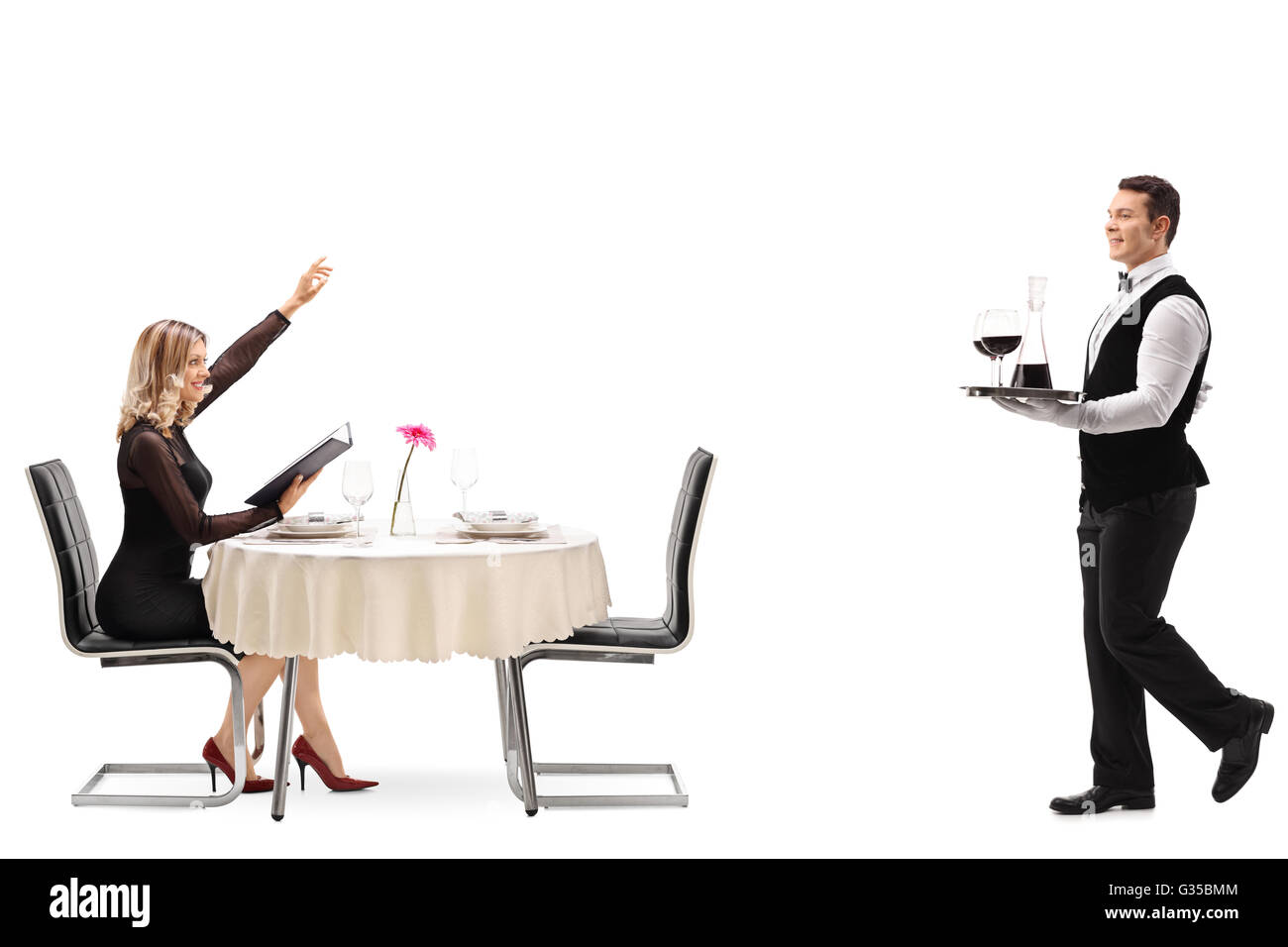 Young woman sitting at a restaurant table and calling the waiter ...