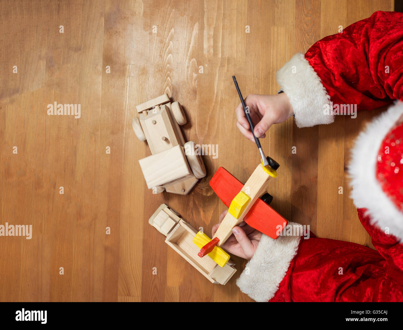 Santa Claus making toys. Painting and coloring wooden toy Stock Photo ...