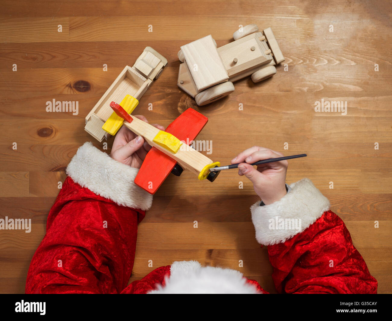 Santa Claus making toys. Painting and coloring wooden toy Stock Photo ...