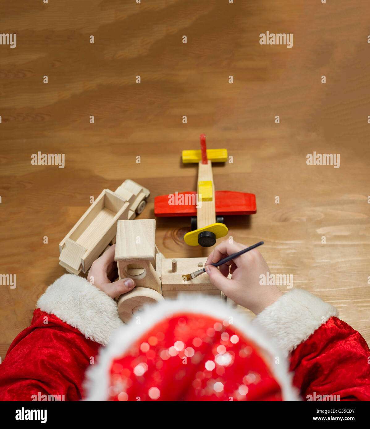 Santa Claus making toys. Painting and coloring wooden toy Stock Photo ...