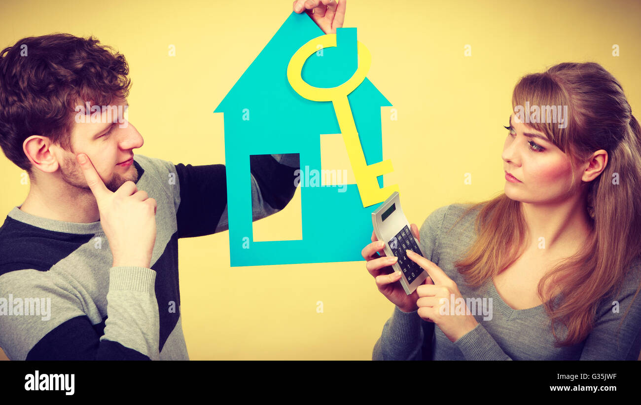 Money and real estate problems. Young worried couple with paper model ...