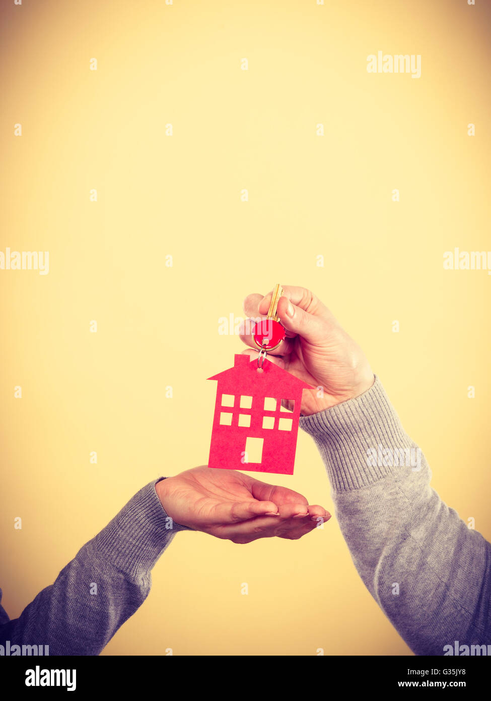 Couple woman and man hands holding new house key with red home shape ...