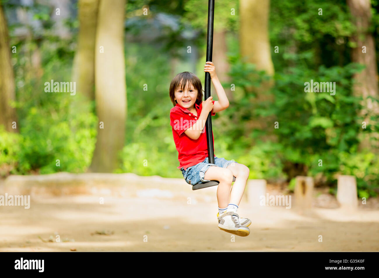 Cute child, boy, rides on Flying Fox play equipment in a children's ...