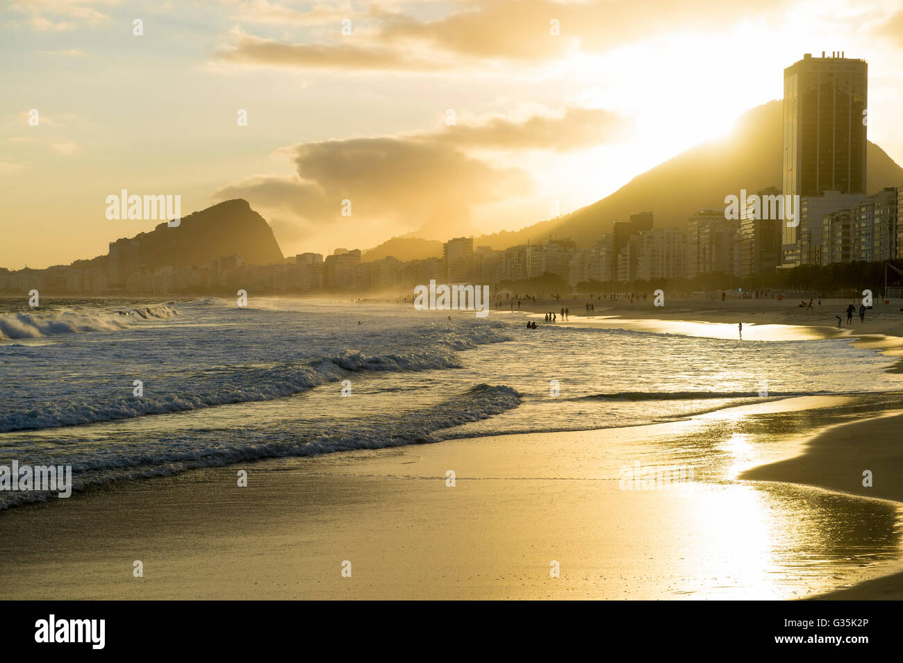 Golden sun setting behind a silhouette of the Rio de Janeiro, Brazil ...