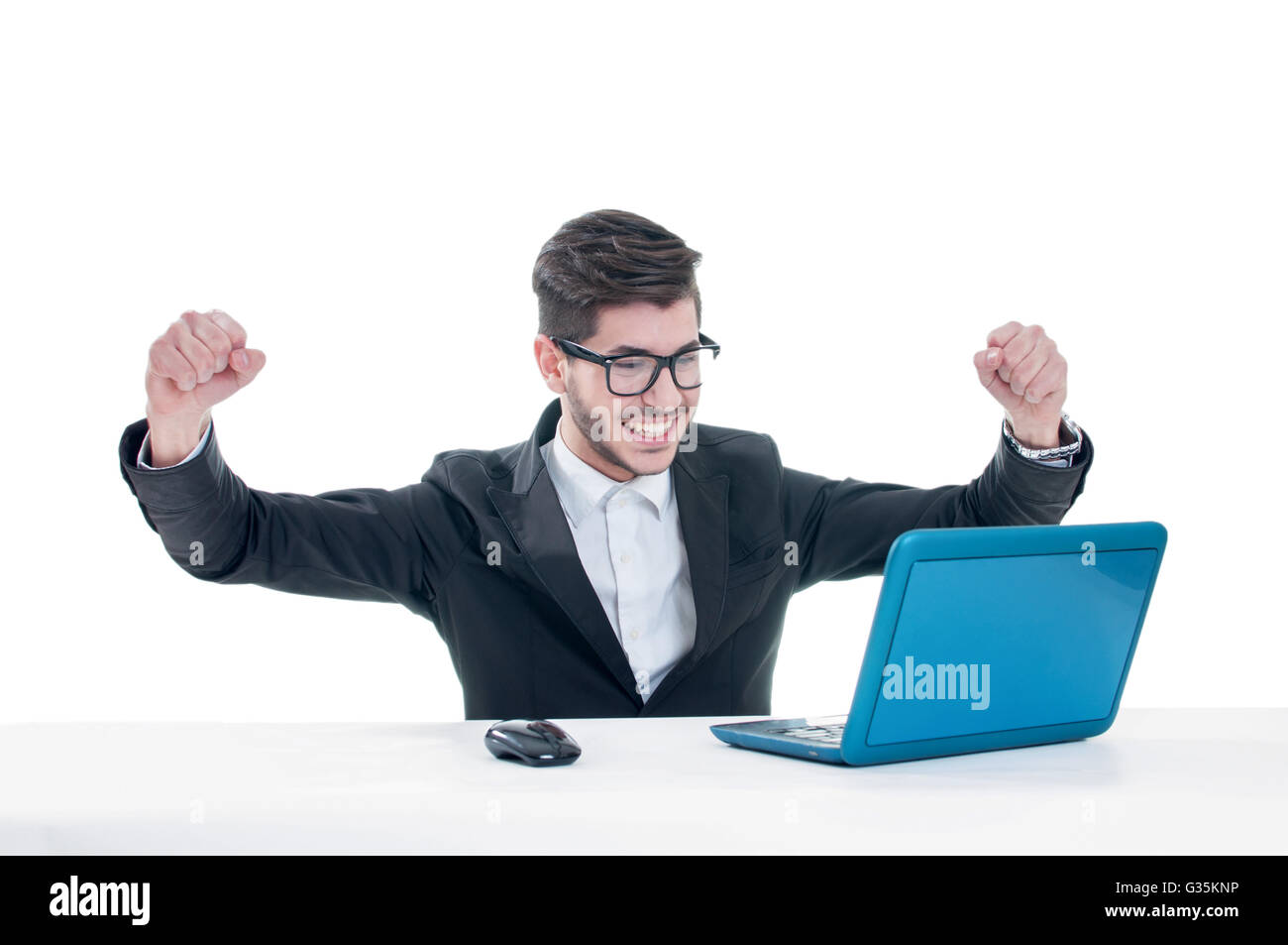 Young man with raised fists using laptop. Isolated on white background ...