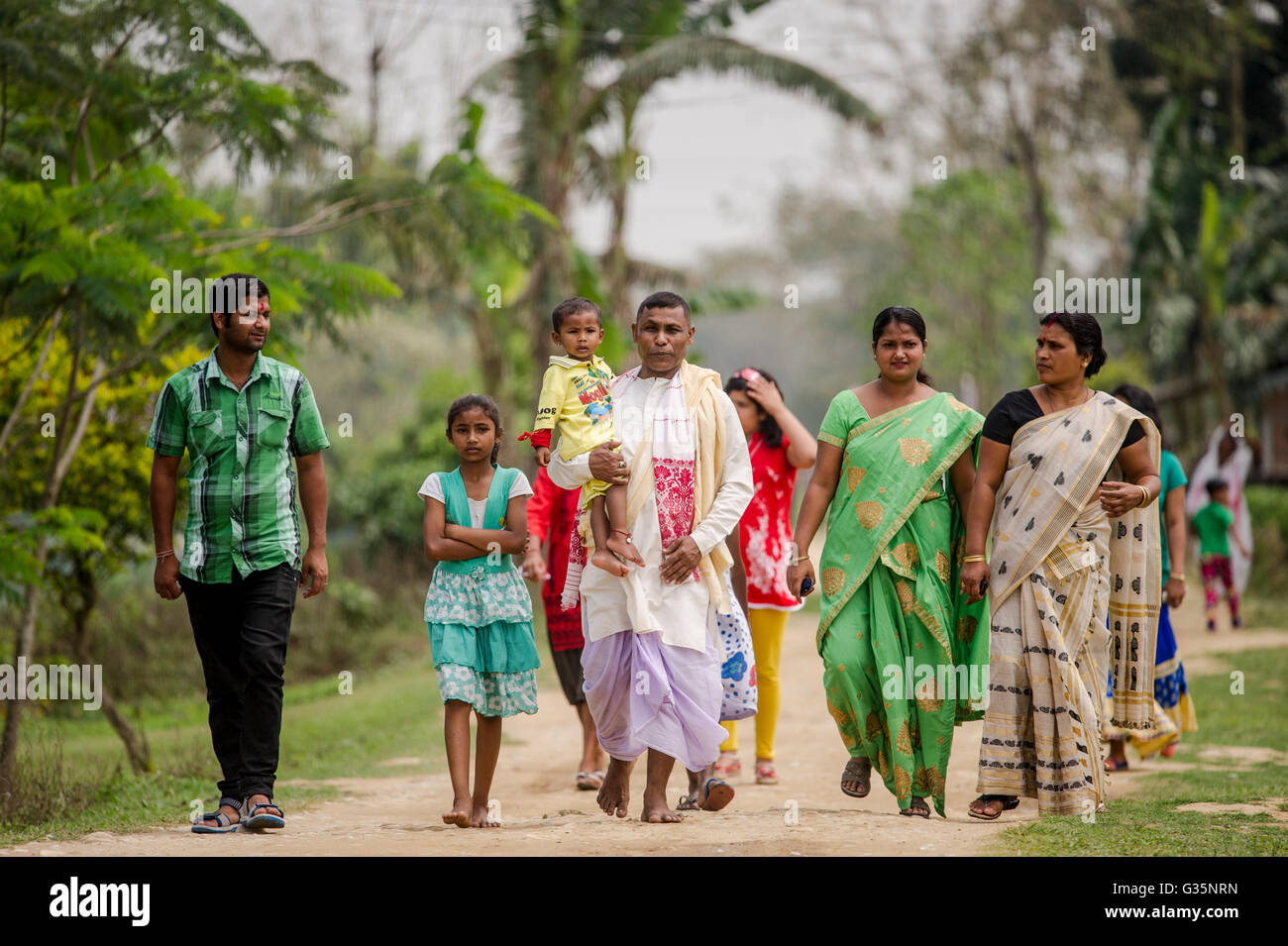 A family walks together in Pan Bari Village in the Kaziranga National ...