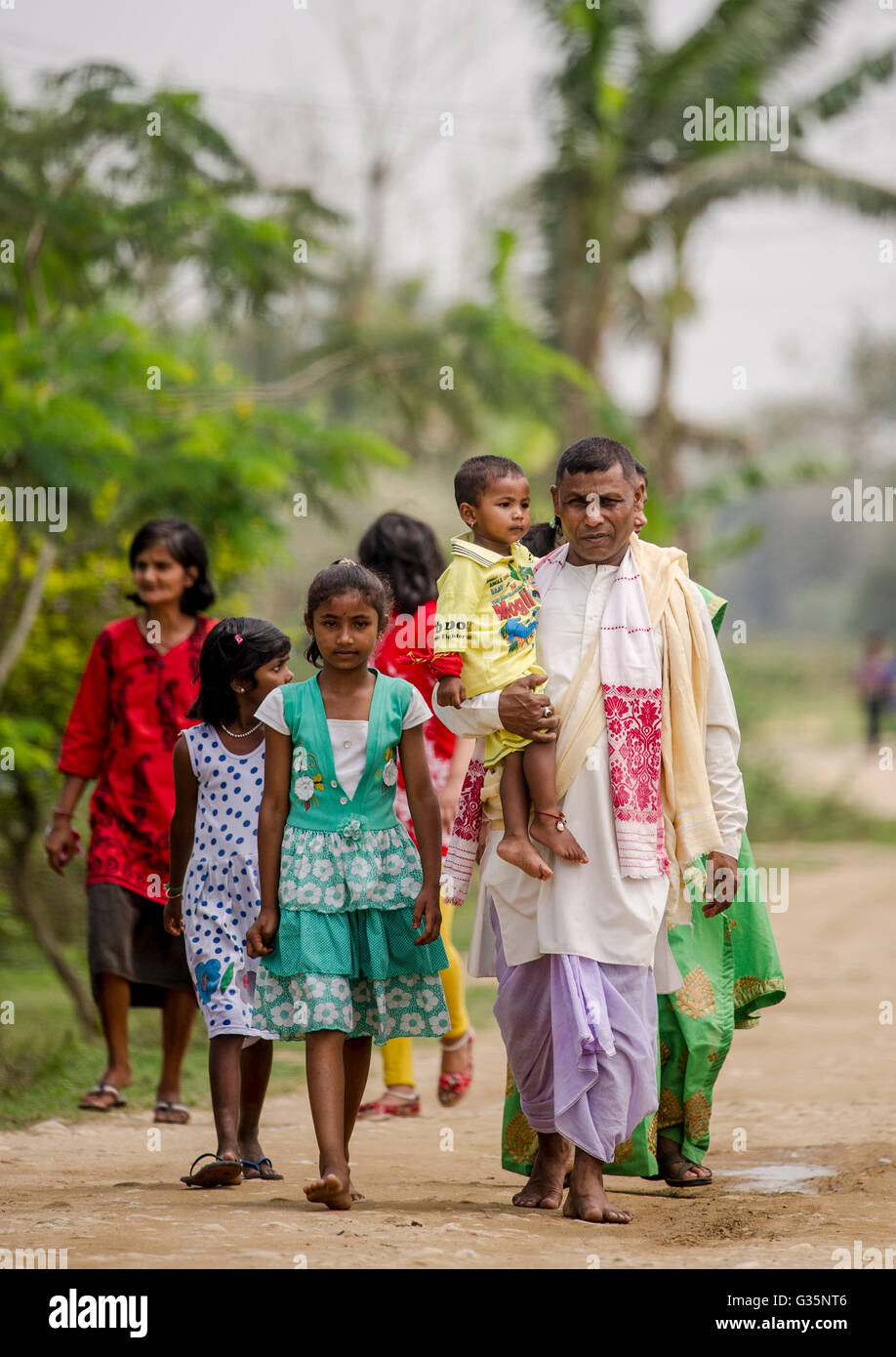 A family walks together in Pan Bari Village in the Kaziranga National ...
