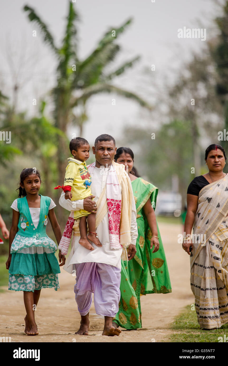 A family walks together in Pan Bari Village in the Kaziranga National ...
