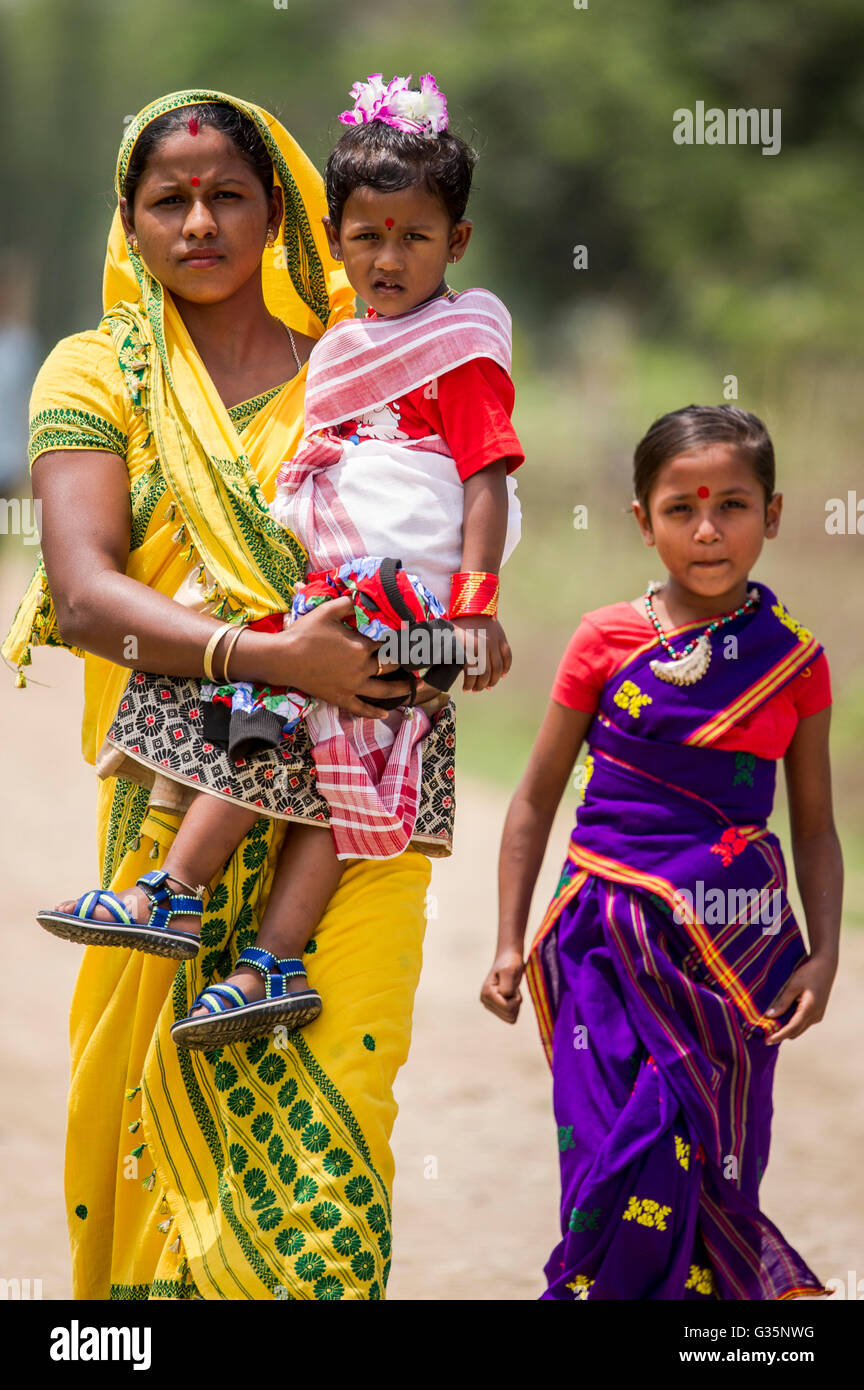 A family walks together in Pan Bari Village in the Kaziranga National ...