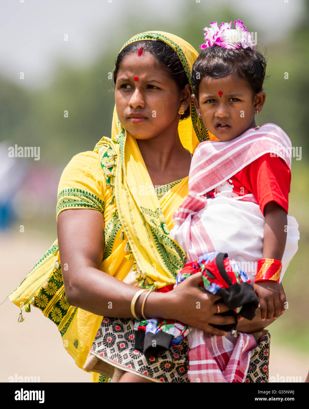 A family walks together in Pan Bari Village in the Kaziranga National ...