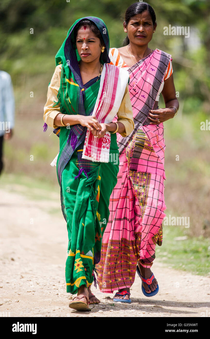 A family walks together in Pan Bari Village in the Kaziranga National ...