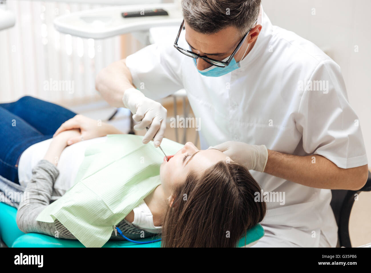Professional dentist doing teeth checkup on female patient dental ...