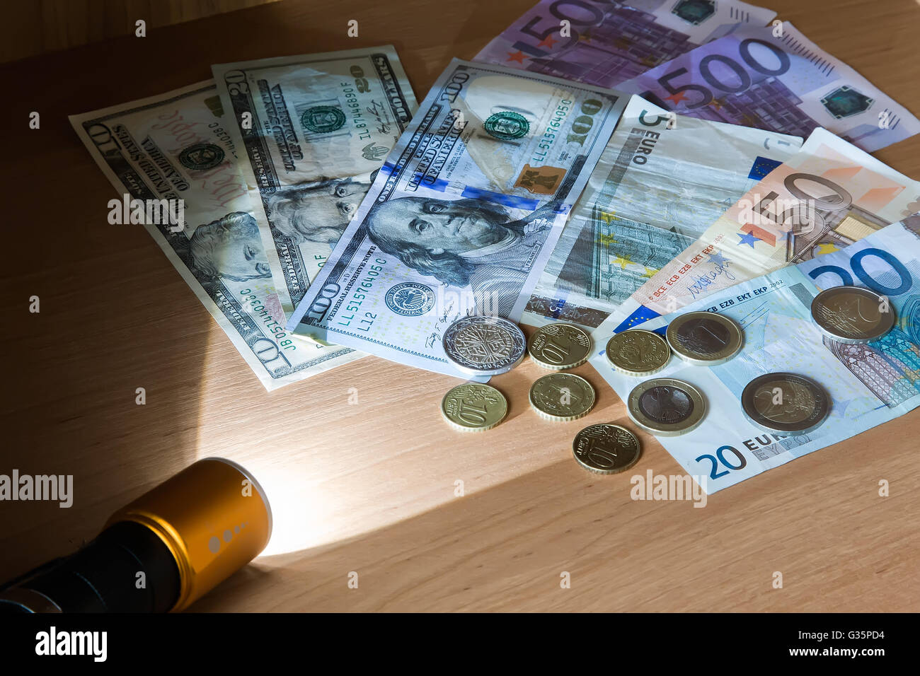 In a dark room a beam of light of the electric lantern lights money ...