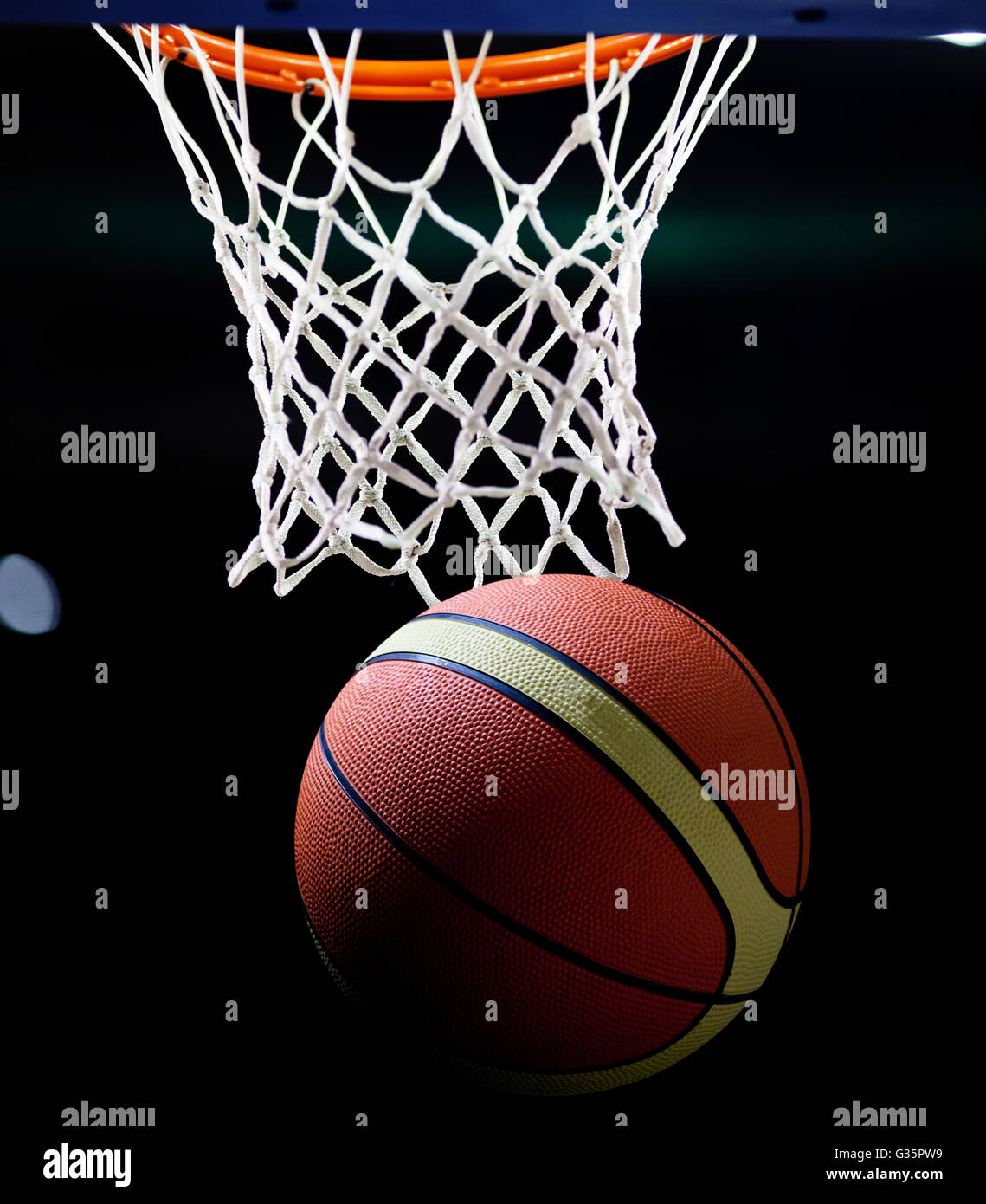 Basketball going through the hoop at a sports arena (intentional ...