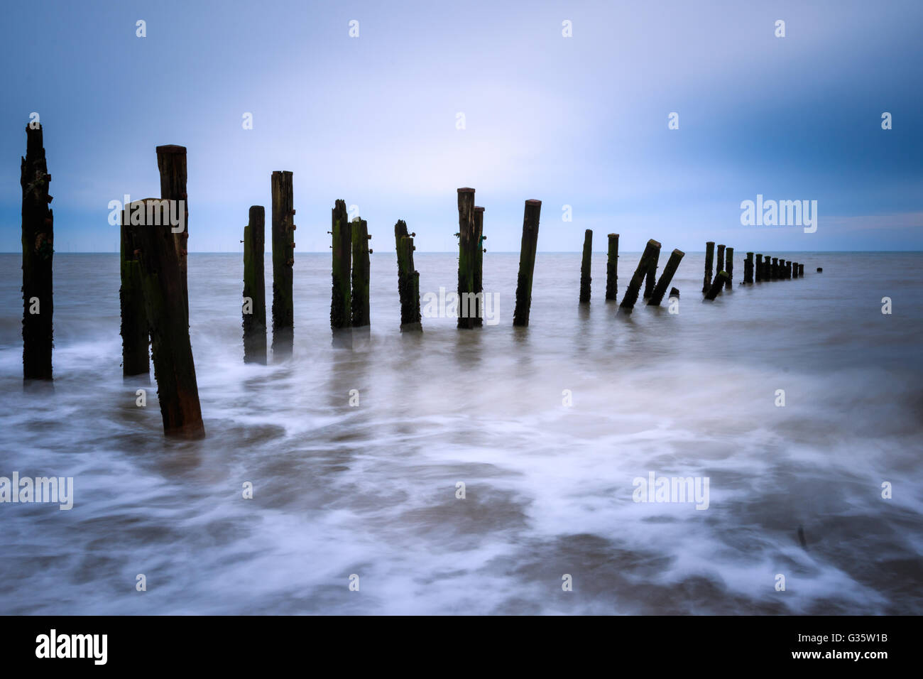 Wooden groynes on the beach with long exposure Stock Photo - Alamy