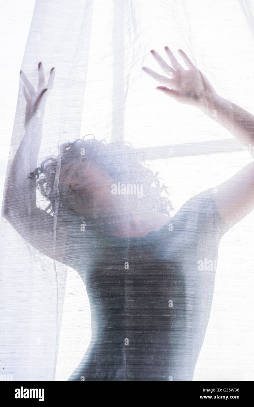 Female figure behind the curtains by the window Stock Photo - Alamy