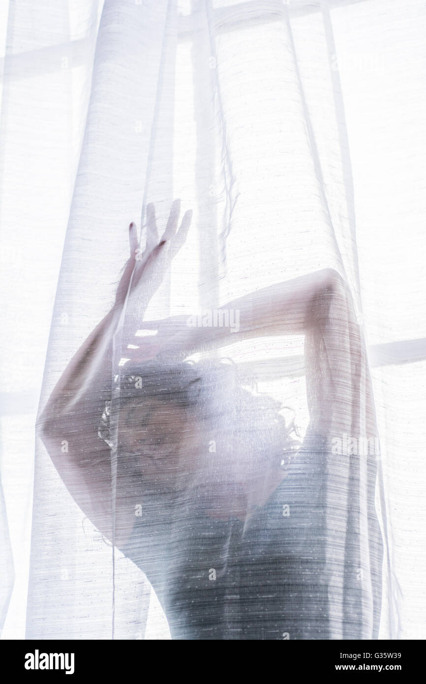 Female figure behind the curtains by the window Stock Photo - Alamy