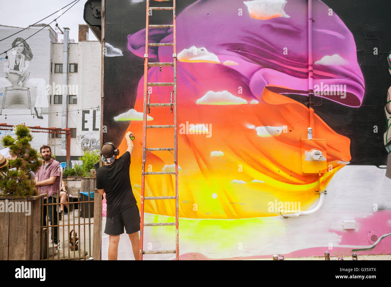 Buff Monster works on his mural in Bushwick, Brooklyn in New York ...