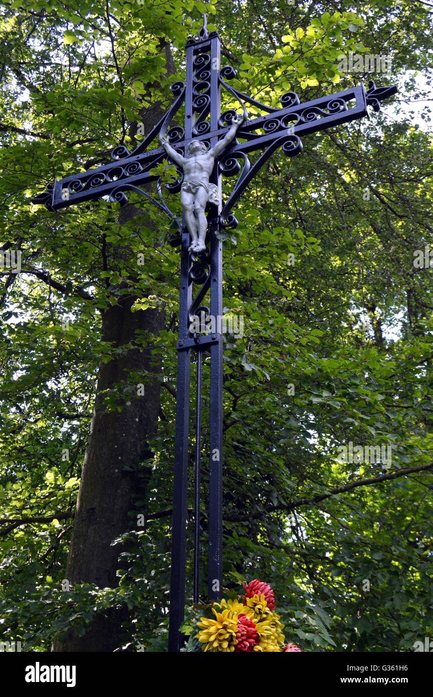 Iron cross to forge with the Christ in the forest Stock Photo - Alamy