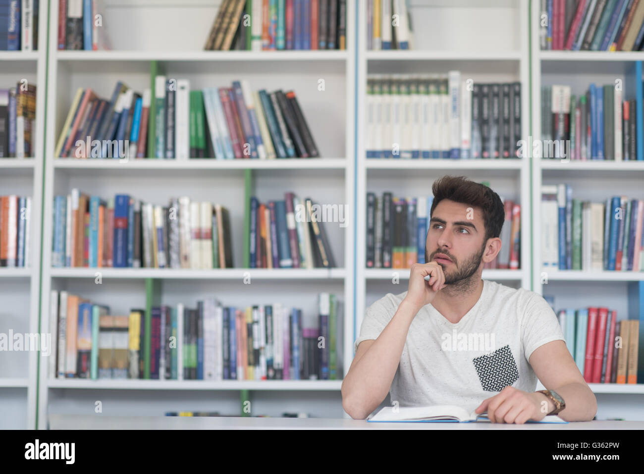 Student reading book in school library. Study lessons for exam. Hard ...