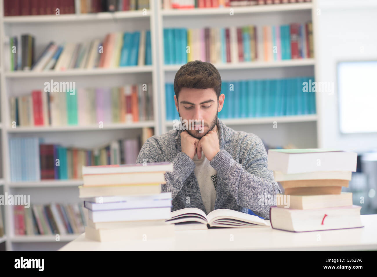 Portrait of happy student while reading book in school library. Study ...