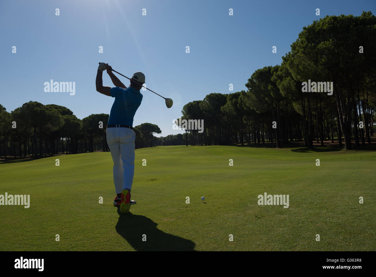 golf player hitting shot with club on course at beautiful morning with ...