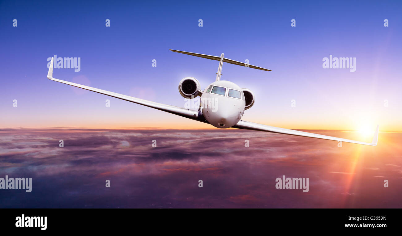 Private jet plane flying above clouds in beautiful sunset. Shot from ...