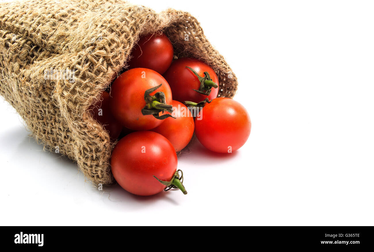 Tomatoes in a hemp sack isolated on white background Stock Photo - Alamy
