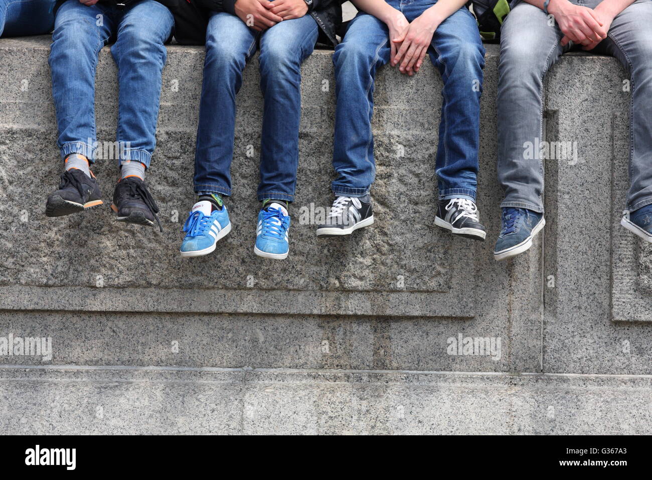 The legs of four people sitting on the base of Nelson's Column in ...