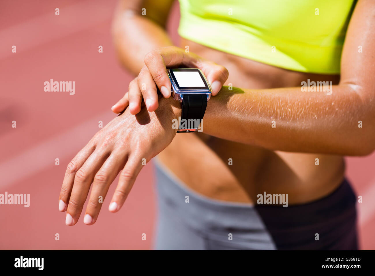Mid-section of female athlete checking her smart watch Stock Photo - Alamy