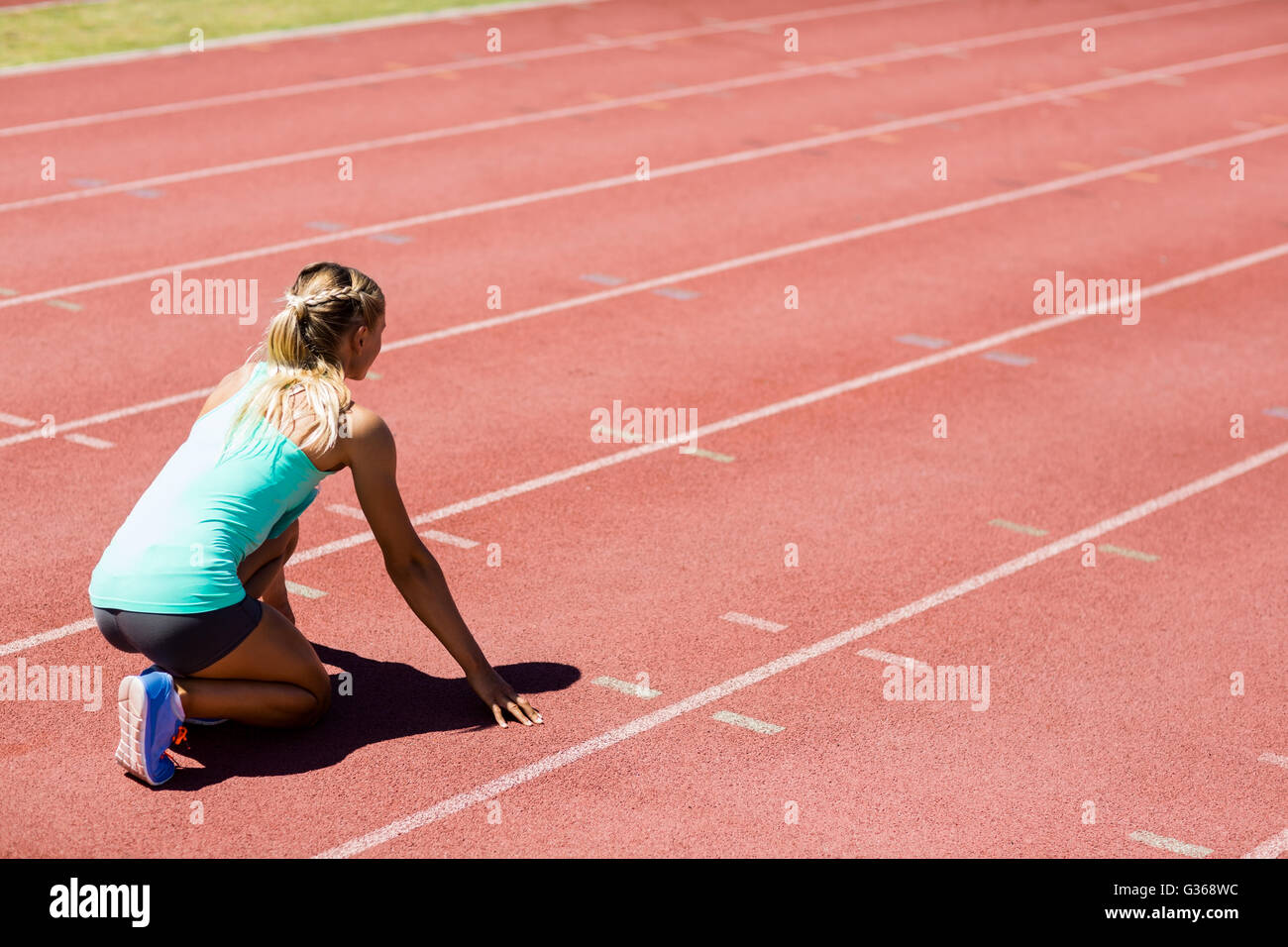 Female athlete ready to run on running track Stock Photo - Alamy