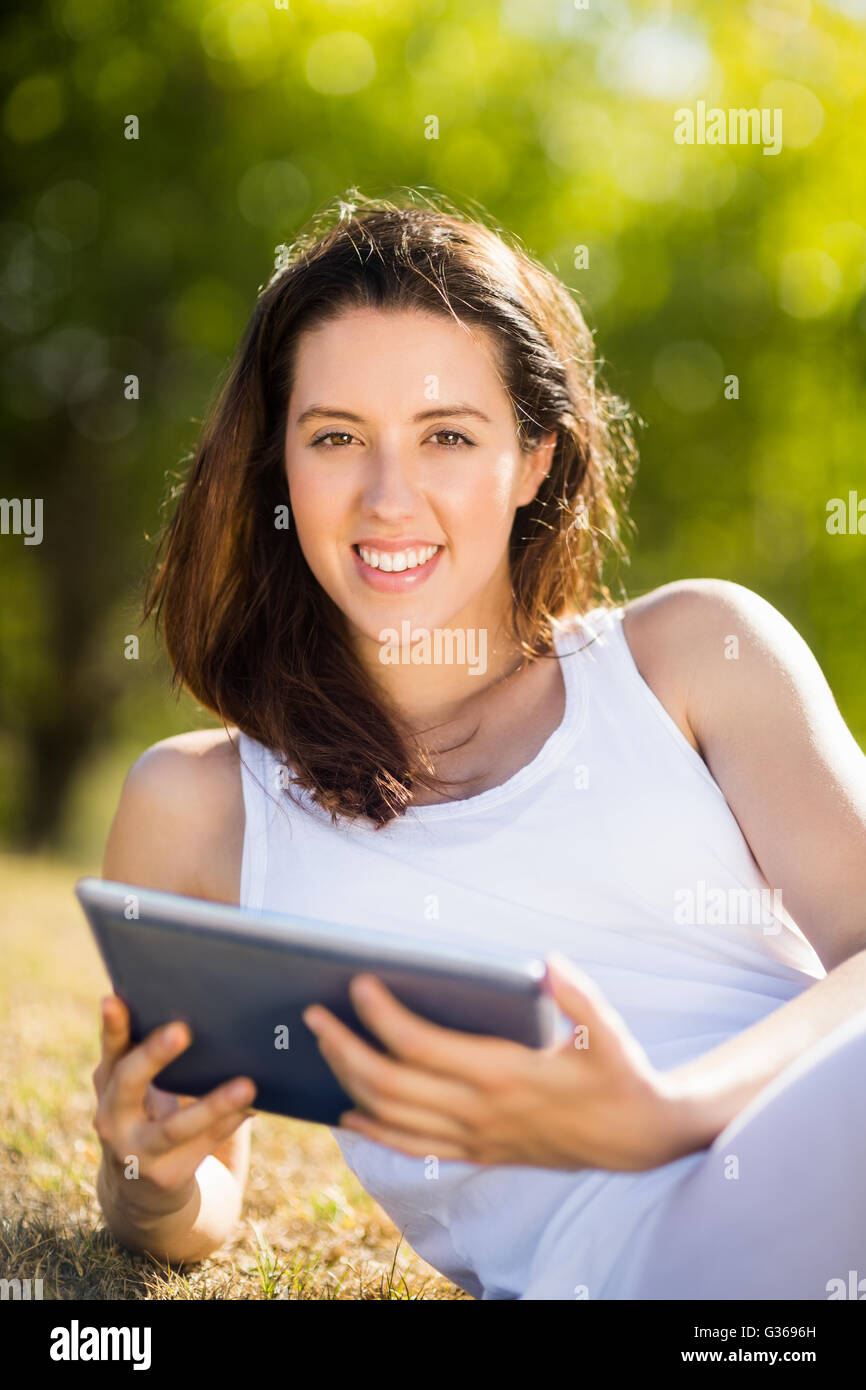 Woman sitting on grass and using digital tablet Stock Photo - Alamy