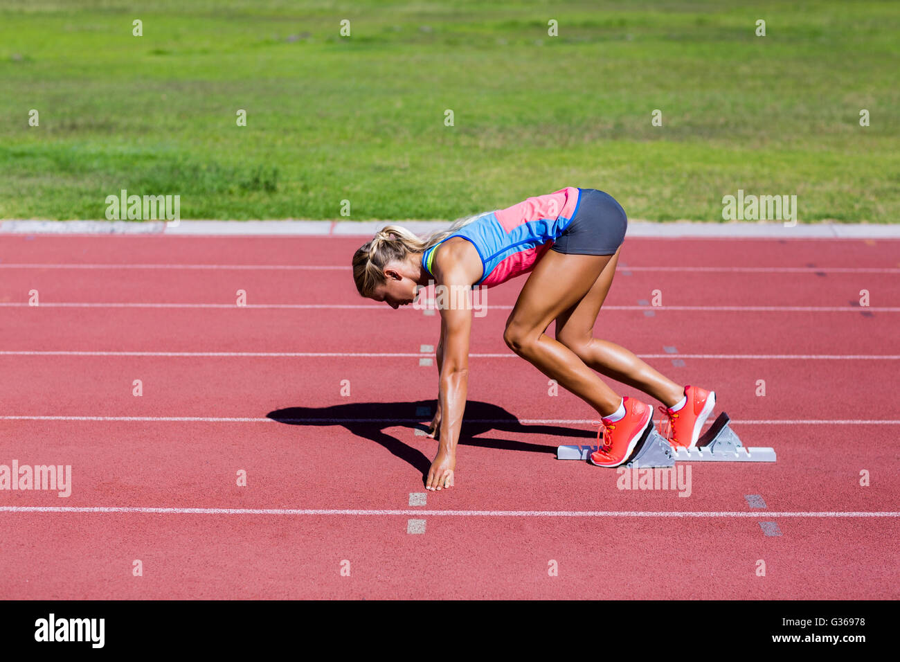 Female athlete ready to run on running track Stock Photo - Alamy