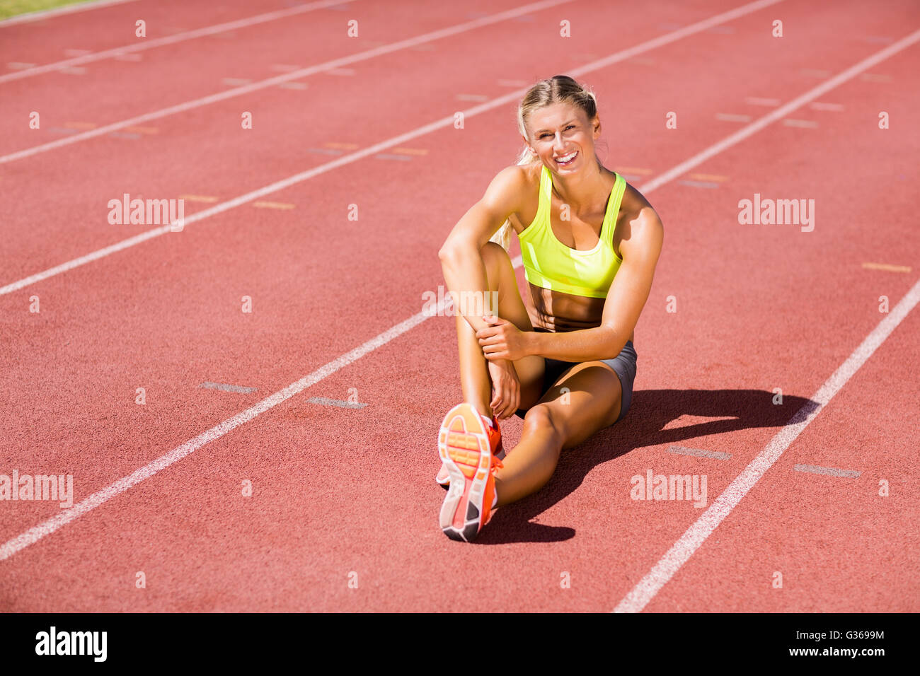 Female athlete sitting on the running track Stock Photo - Alamy