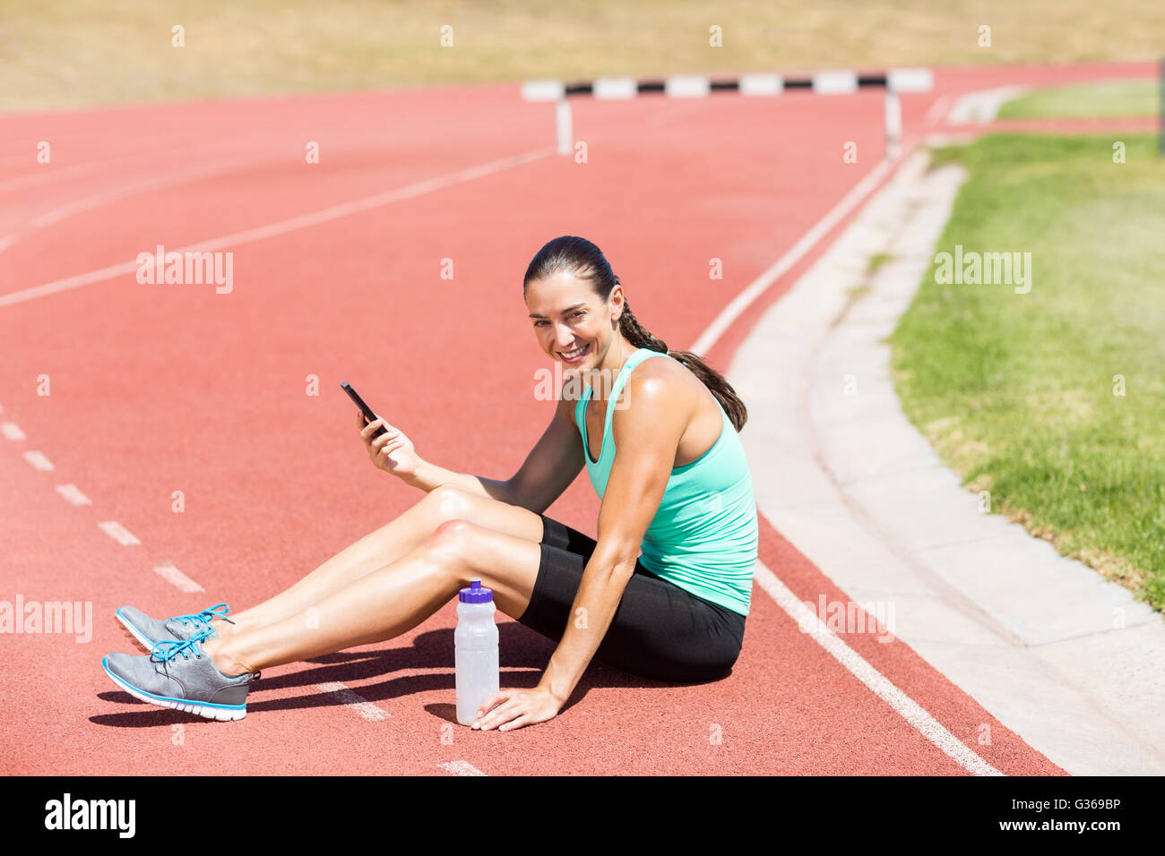 Portrait of happy female athlete using mobile phone Stock Photo - Alamy