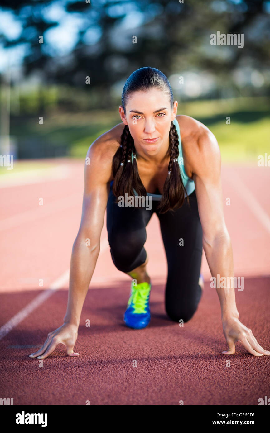 Portrait of female athlete in ready to run position Stock Photo - Alamy