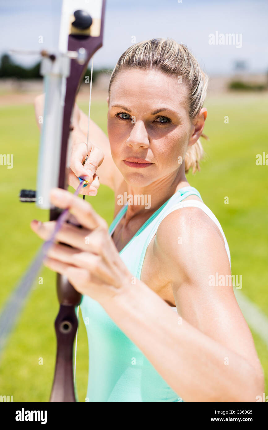 Confident female athlete practicing archery Stock Photo - Alamy