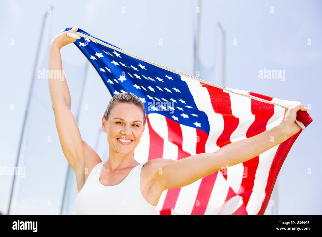 Happy female athlete holding up american flag Stock Photo - Alamy